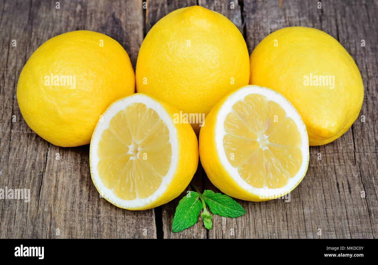 Group of ripe whole yellow lemon citrus fruit with lemon fruit half on ...