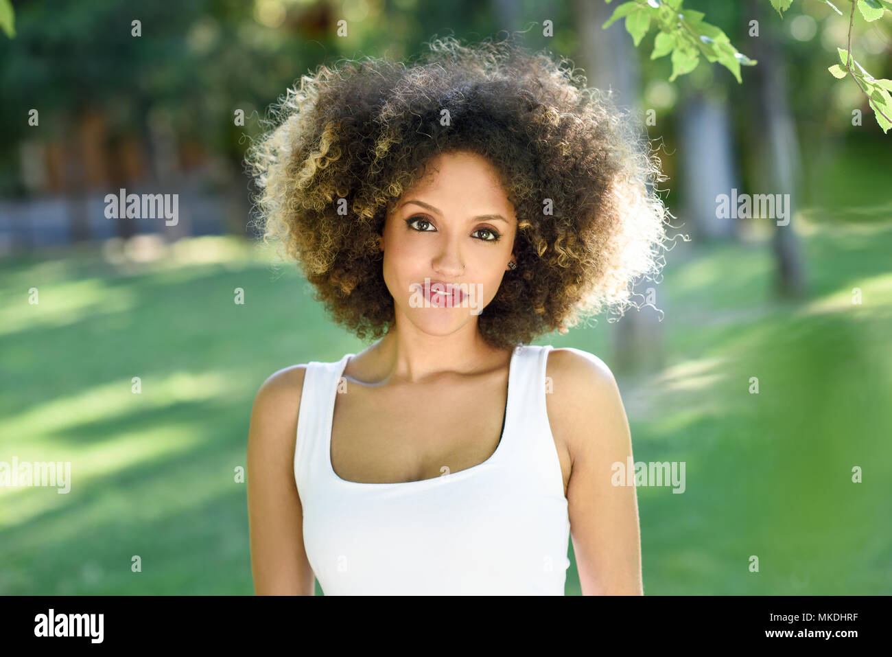 Portrait of young black woman with afro hairstyle in urban park. Mixed ...