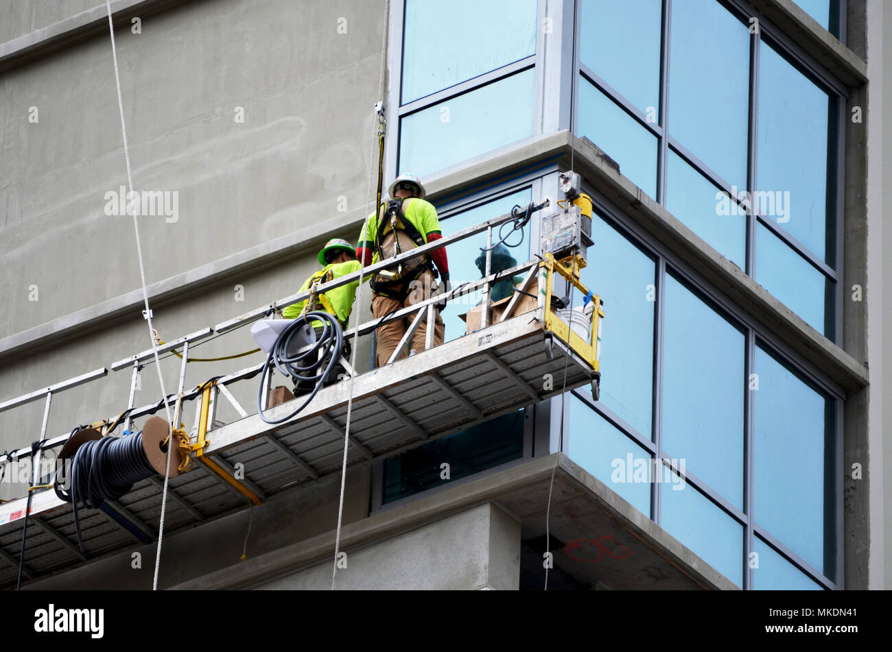 Construction workers on hoist Stock Photo - Alamy