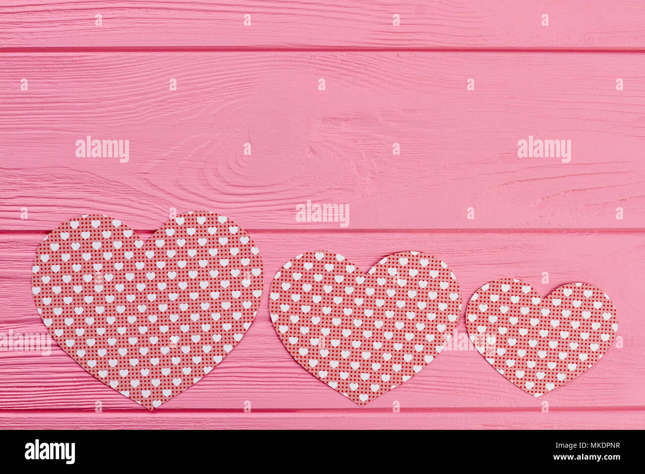 Row of paper hearts on pink wooden background. Set of heart shaped ...