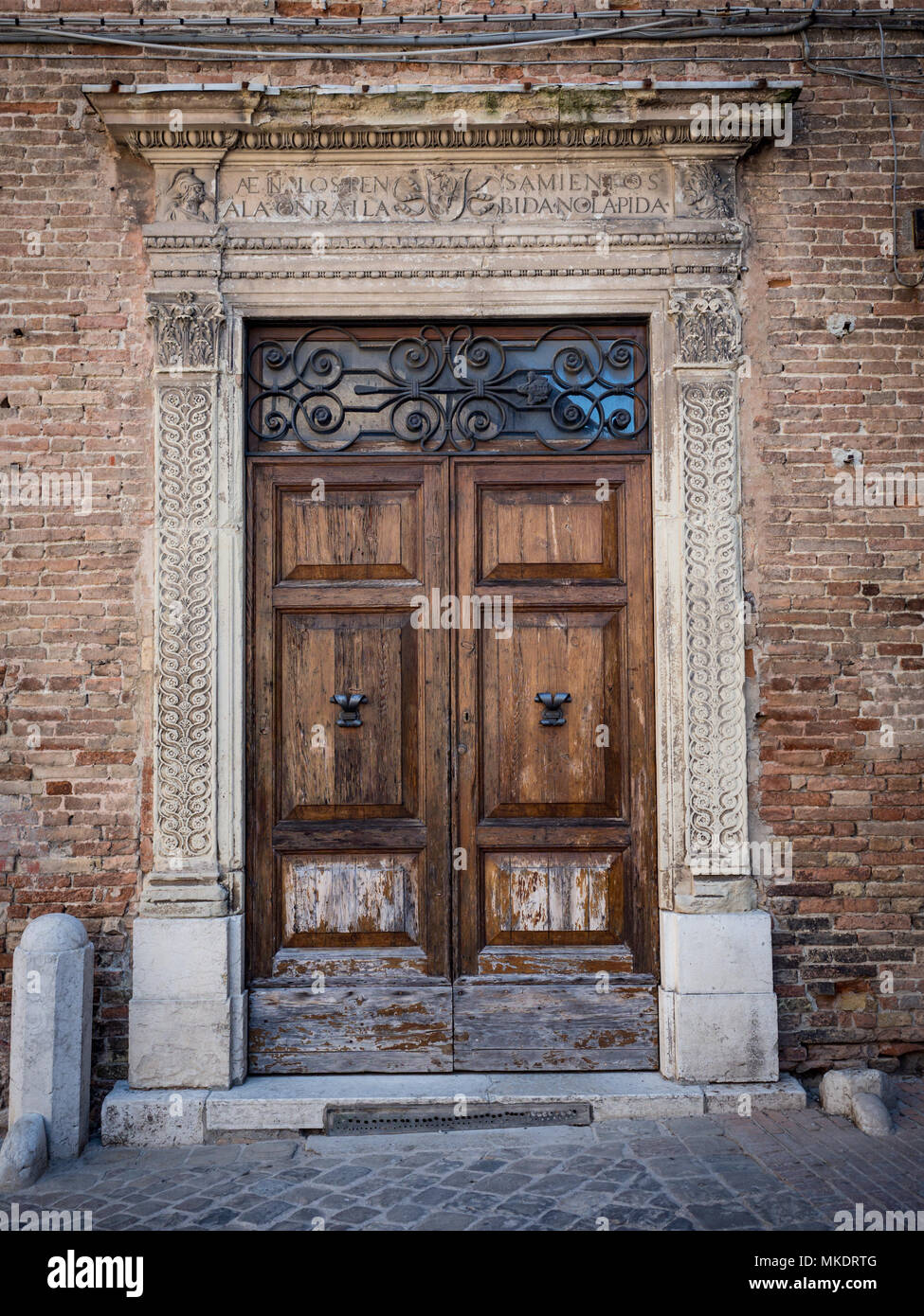 Old wooden portal with columns and architrave in white stone carved ...