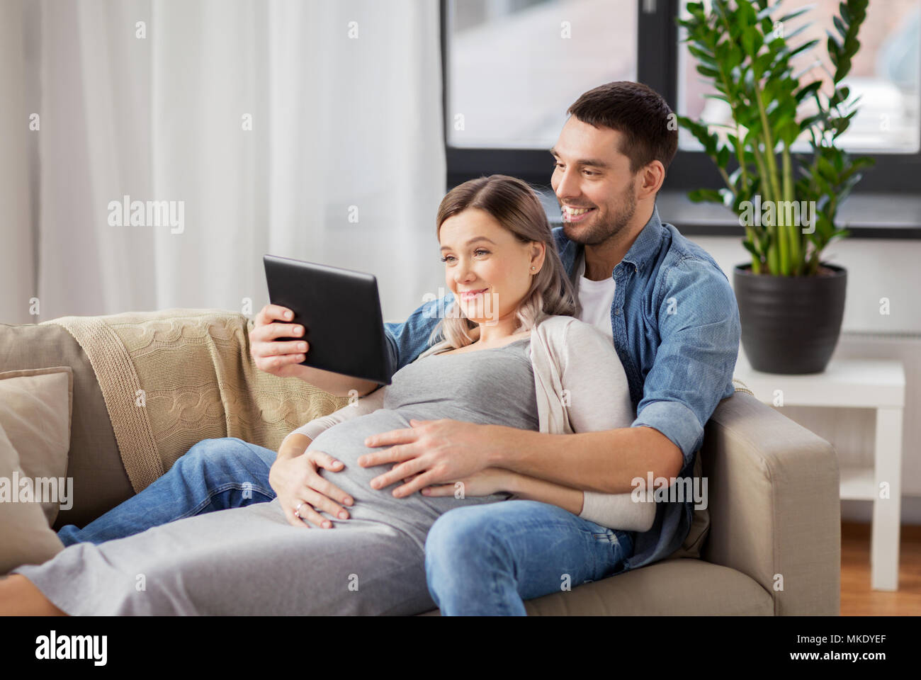 Happy pregnant couple tablet hi-res stock photography and images - Alamy