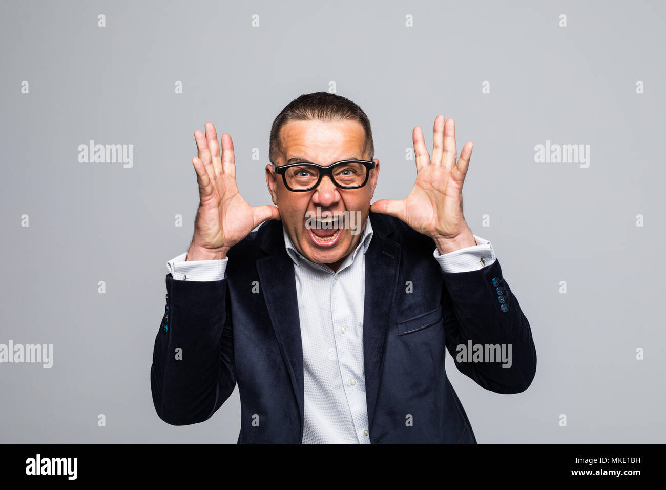 Happy young man in formalwear shouting while looking at camera and ...