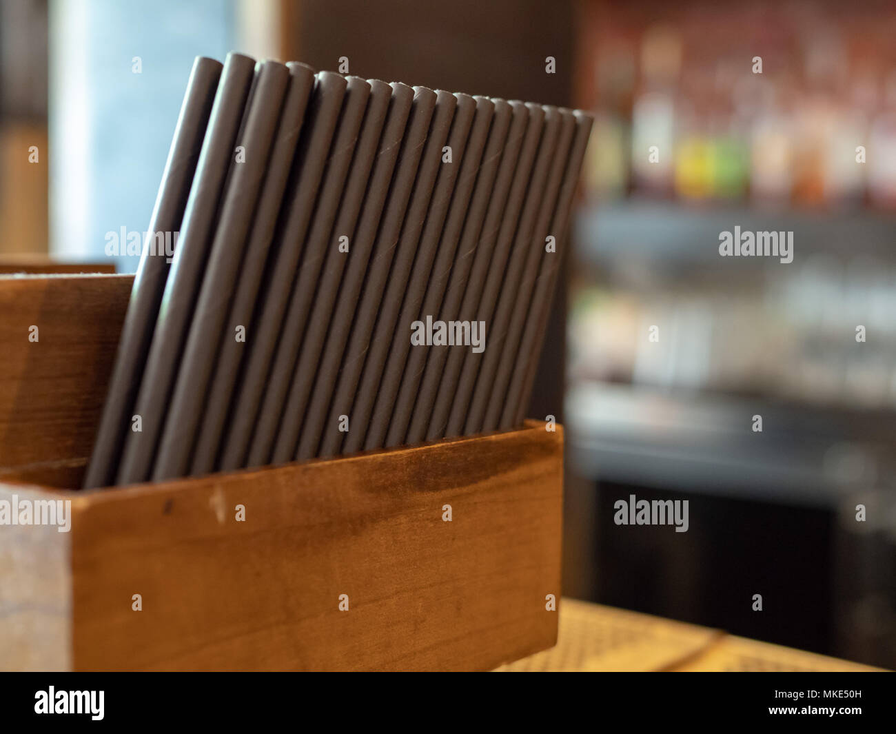 Container filled with paper straws at a bar ready to be used in drinks ...