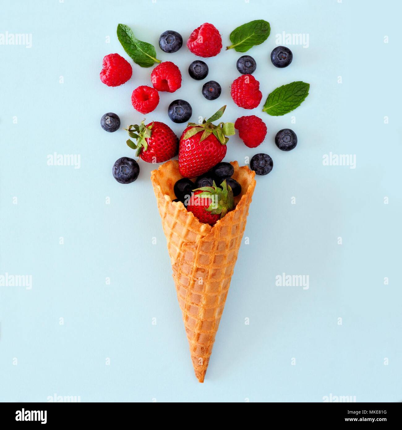 Assorted berry fruit in waffle ice cream cone. Flat lay concept over a ...