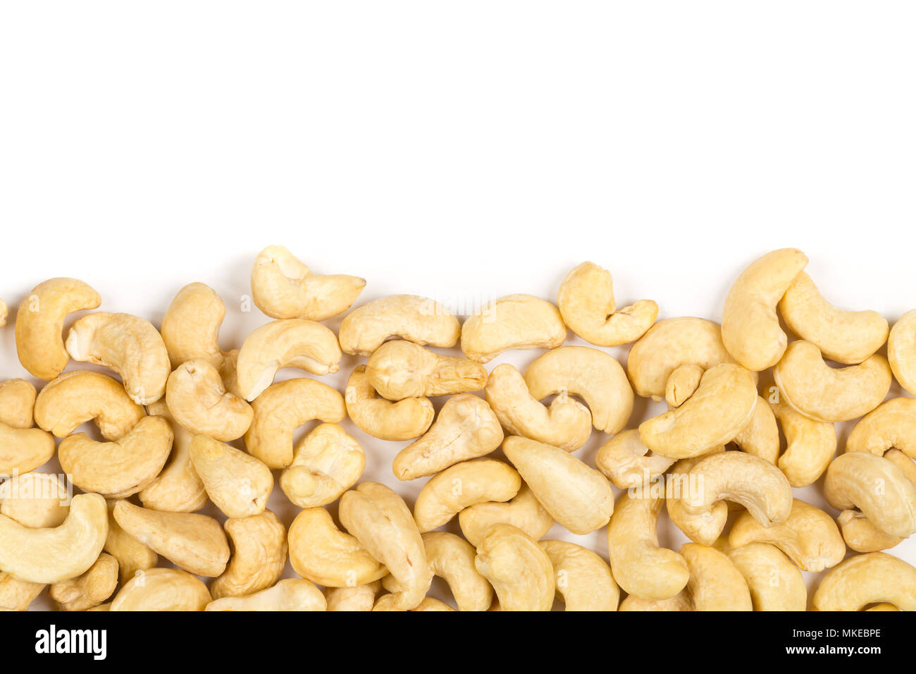 Border of raw, organic, whole cashew nut kernels over white background ...