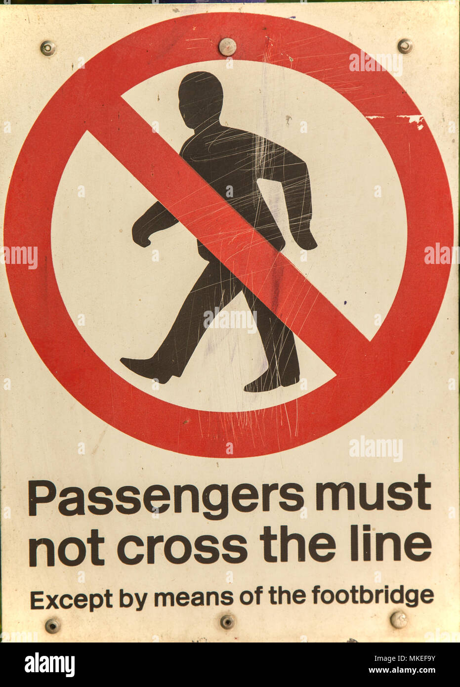 A sign warning passengers that they must not cross the railway lines ...