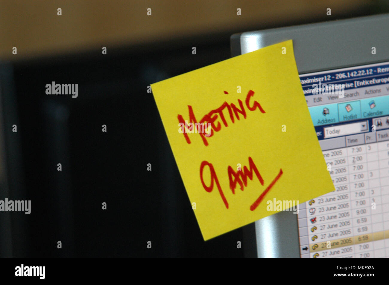 meeting at 9am written on Post-it Note reminder stuck on to computer in ...