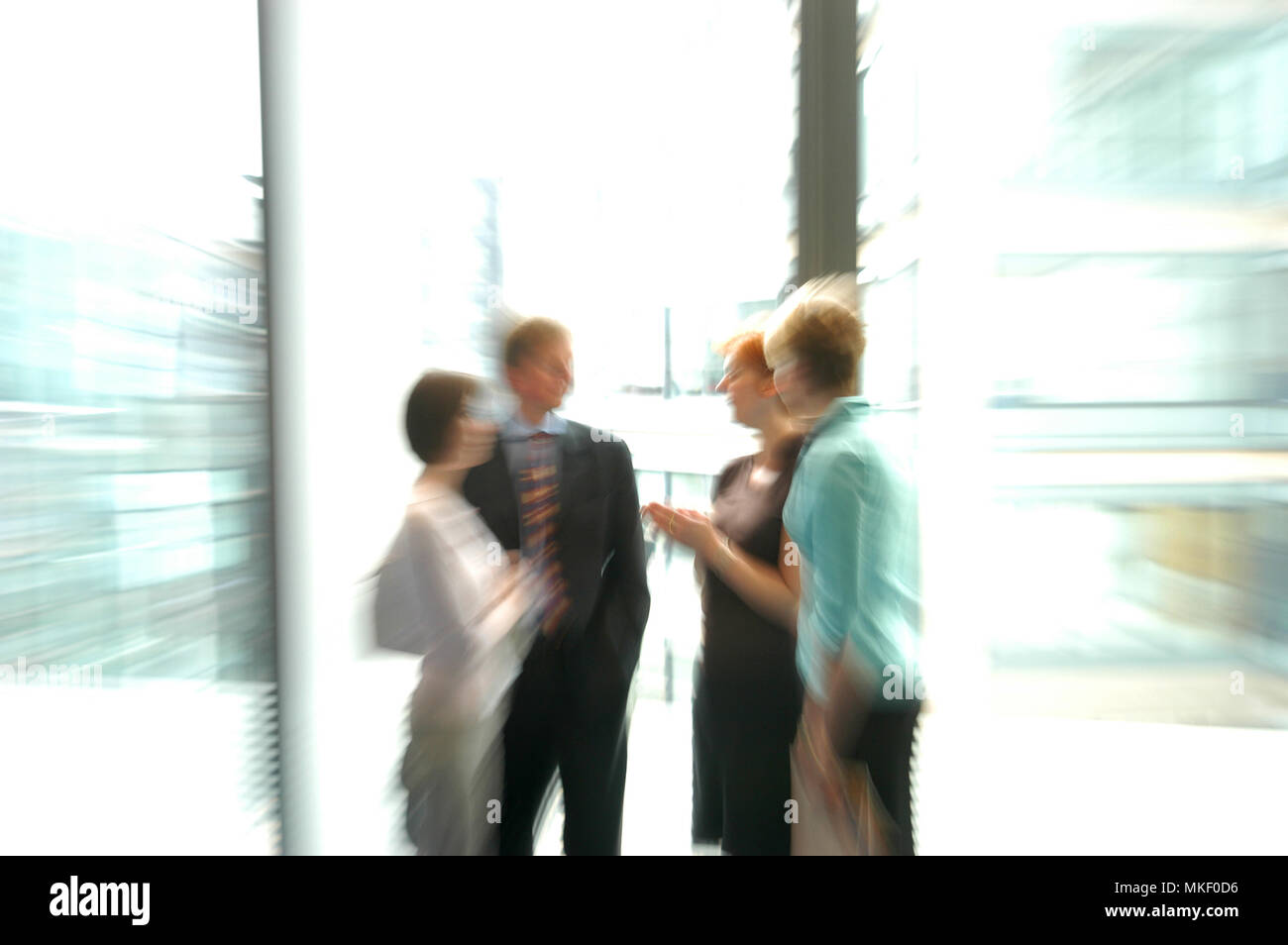 group of men and women talking in bright new, sunny offices in london ...