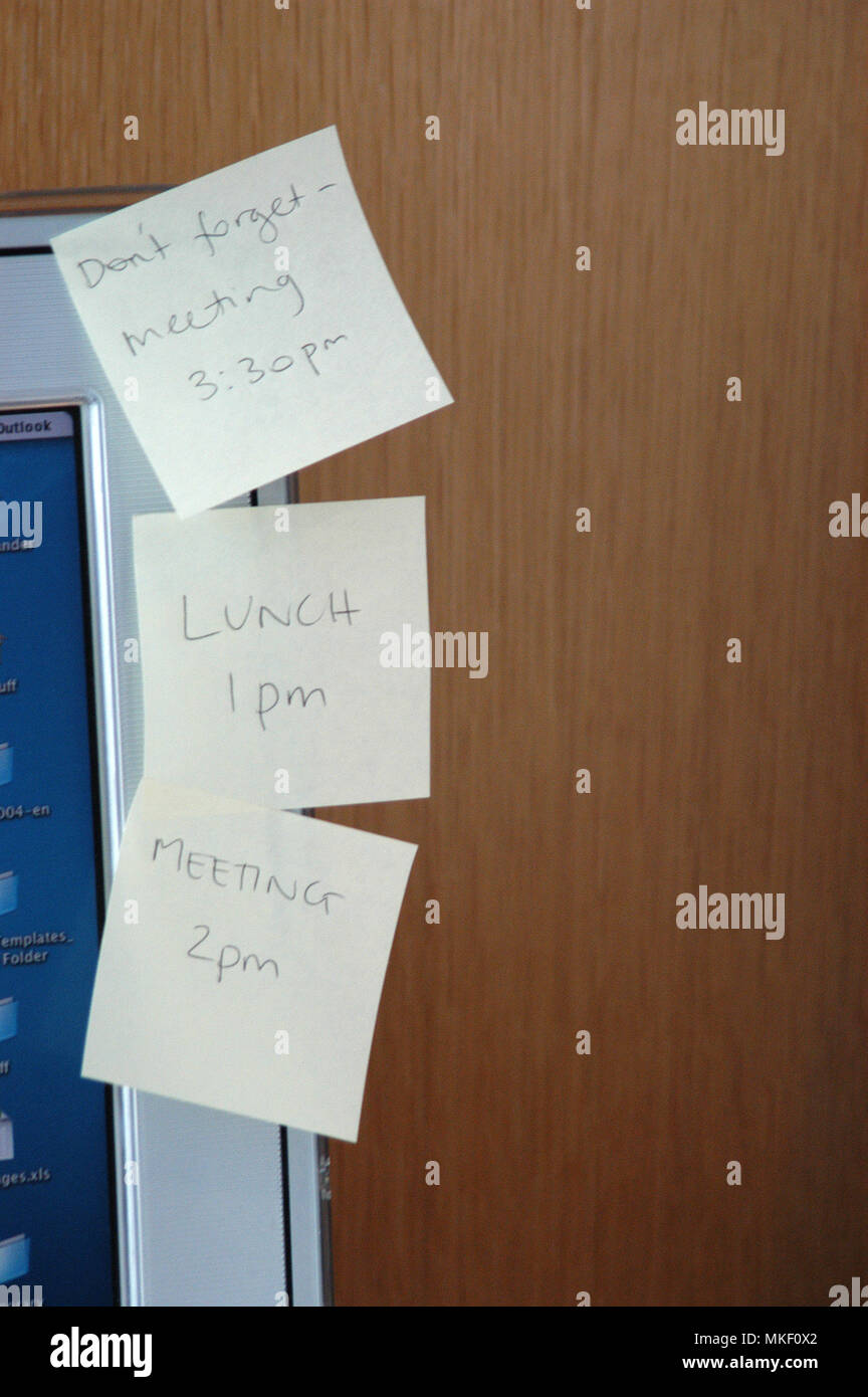 three Post-it Notes sticky note reminders stuck on office desks in the ...