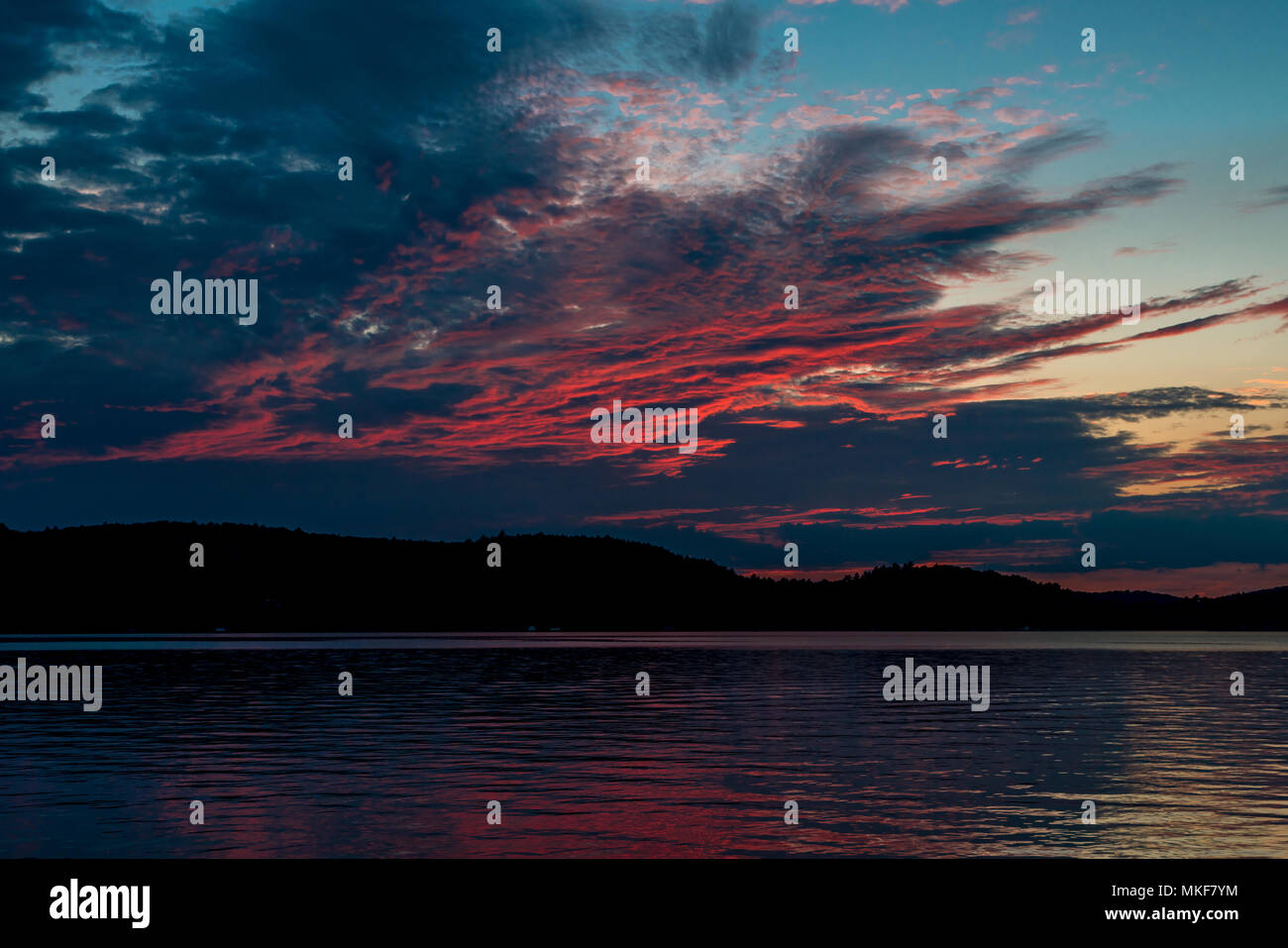 Dramatic view of beautiful vibrant twilight sky, over lake at sunset ...