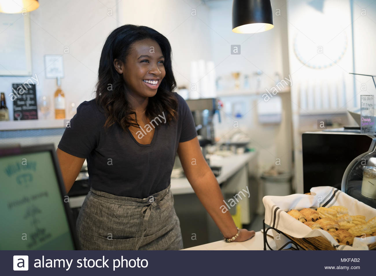 Woman smiling behind bakery counter hi-res stock photography and images ...