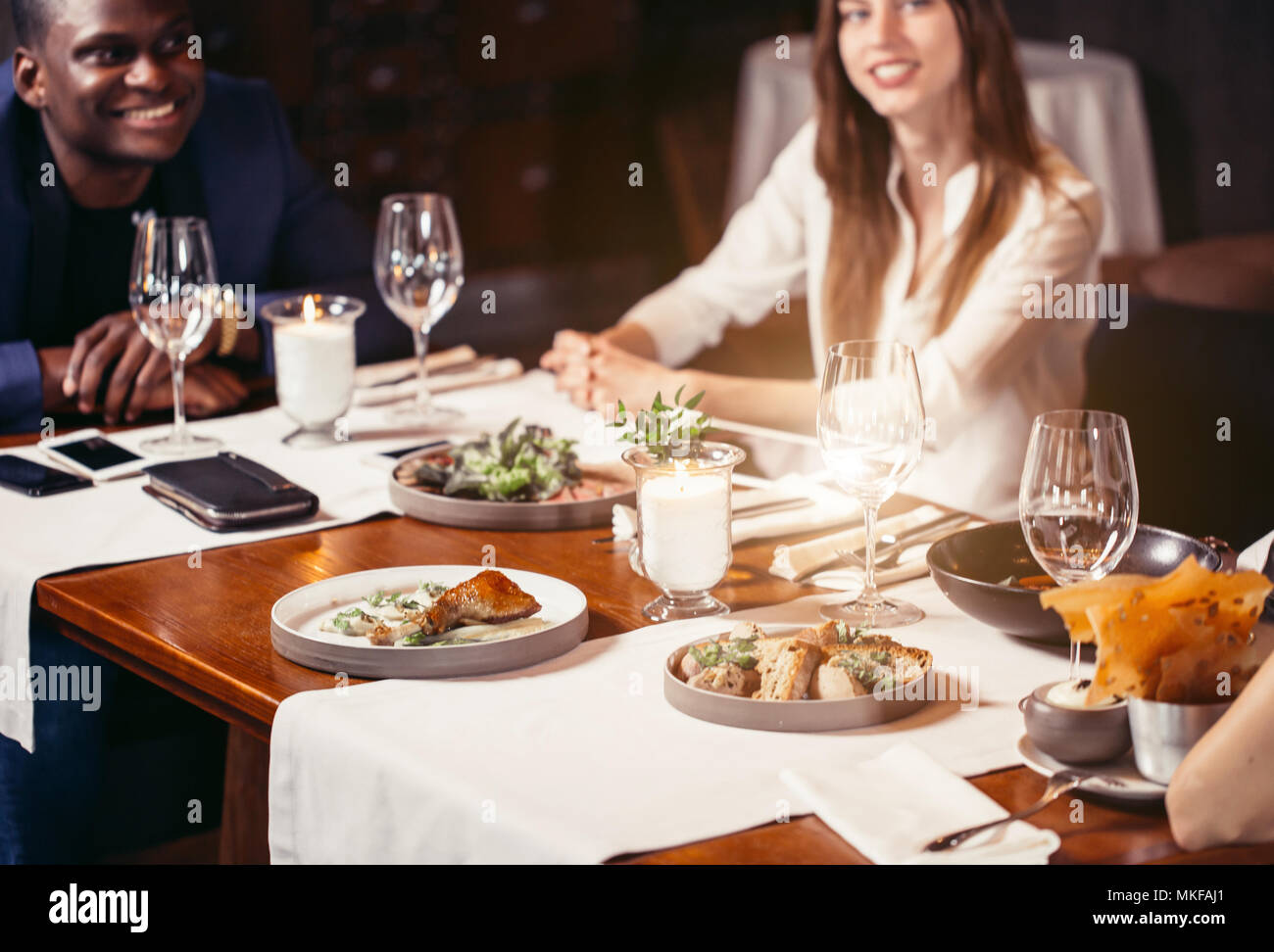 Group of friends sitting at the served for dinner table at restaurant ...