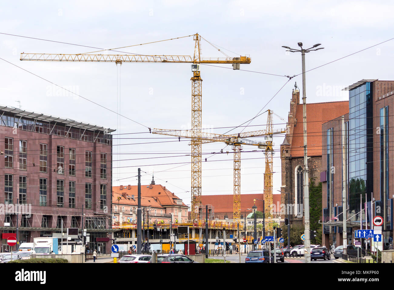 Construction site near the Gothic church. Cranes, western brick facade ...