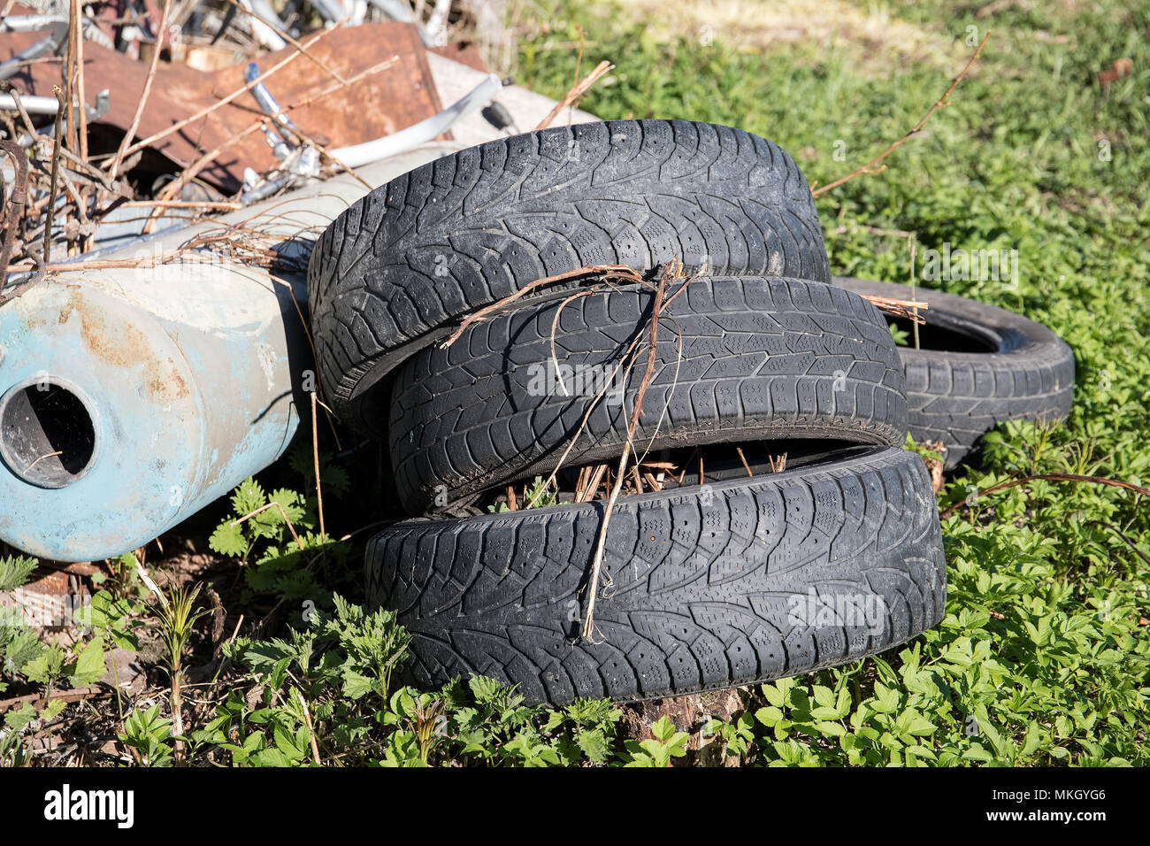 Pile of many old, used tires in the green grass Stock Photo - Alamy