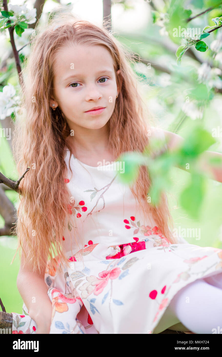 Adorable little girl in blooming apple tree garden on spring day Stock Photo - Alamy