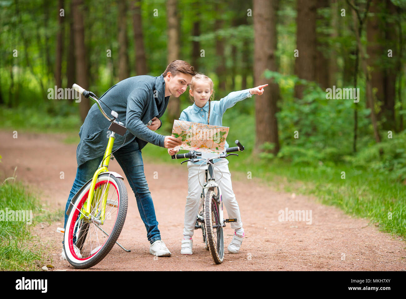 Happy family biking outdoors at the park Stock Photo - Alamy
