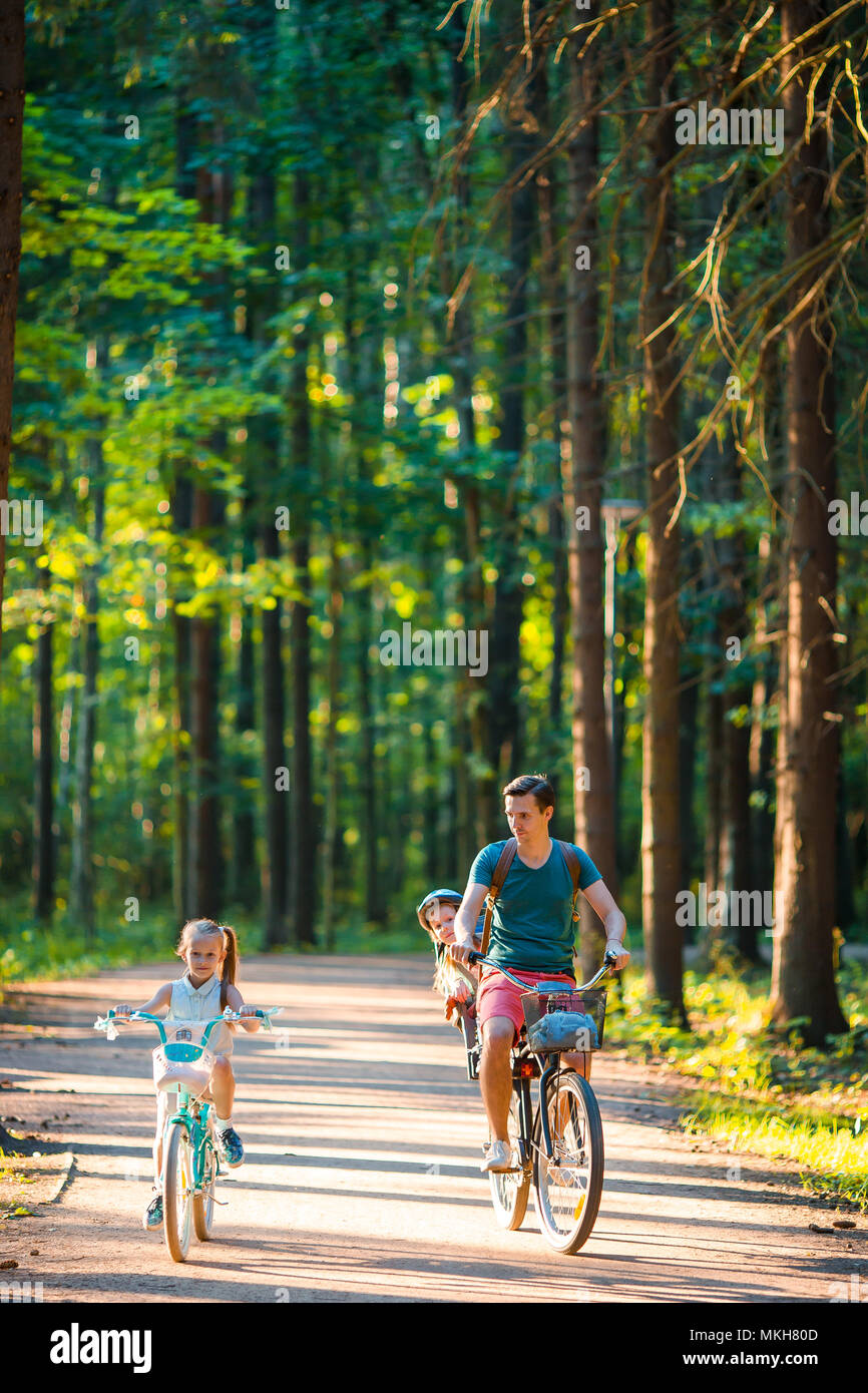 Happy family biking outdoors at the park Stock Photo - Alamy