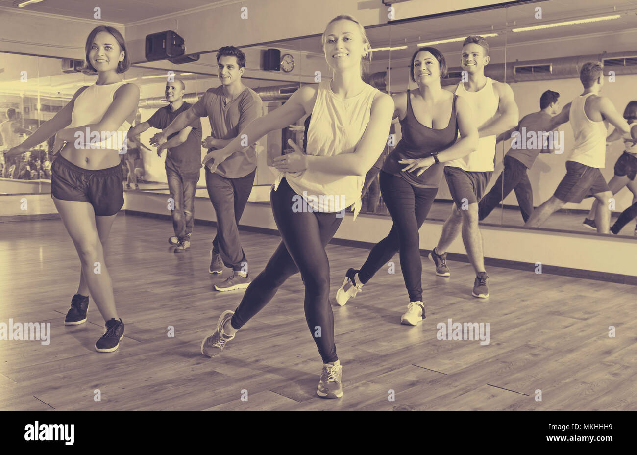 Happy active men and ladies dancing zumba at lesson Stock Photo - Alamy