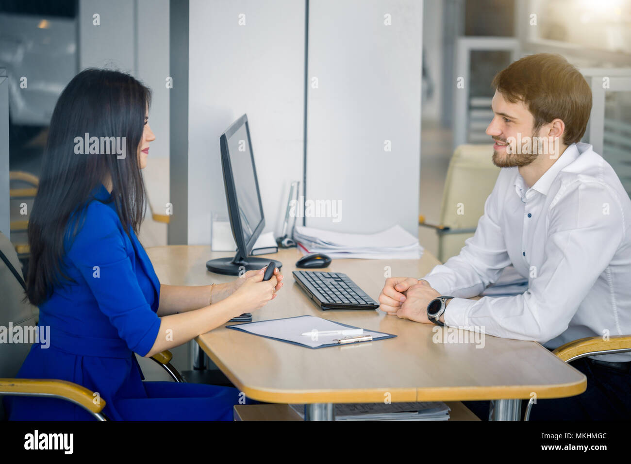 Side view of dialogue between woman customer and car dealership worker ...