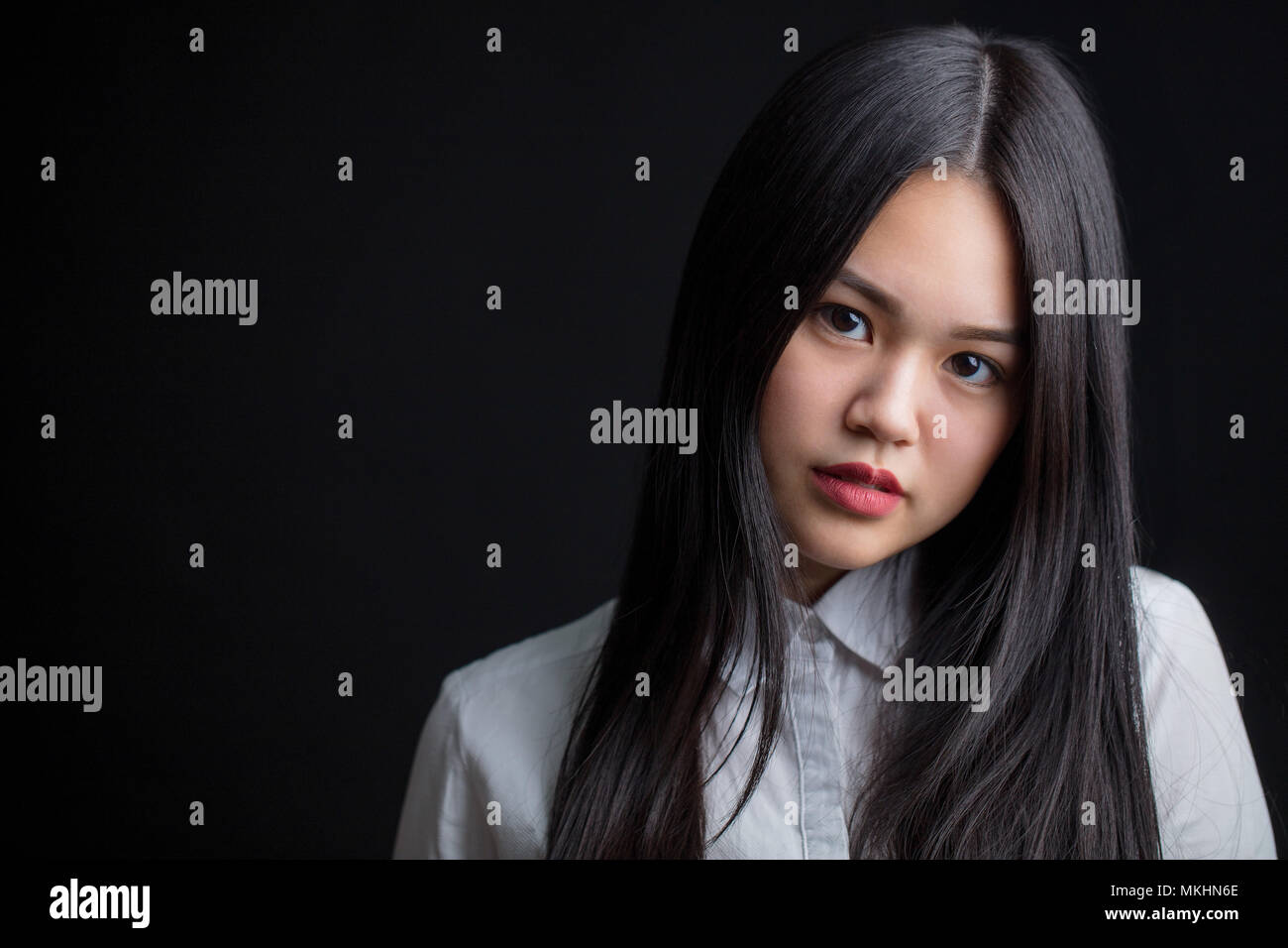 Close up of appealing young asian woman with beautiful piercing eyes ...