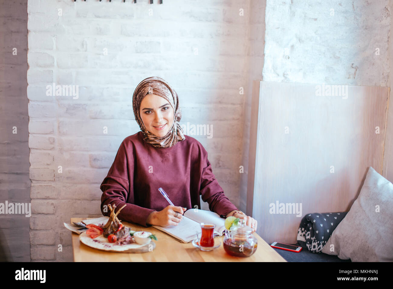 Muslim woman writing love diary in cafe Stock Photo - Alamy