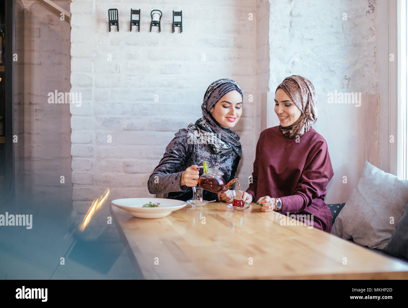 two Pretty caucasian muslim woman drinking tea in cafe Stock Photo - Alamy