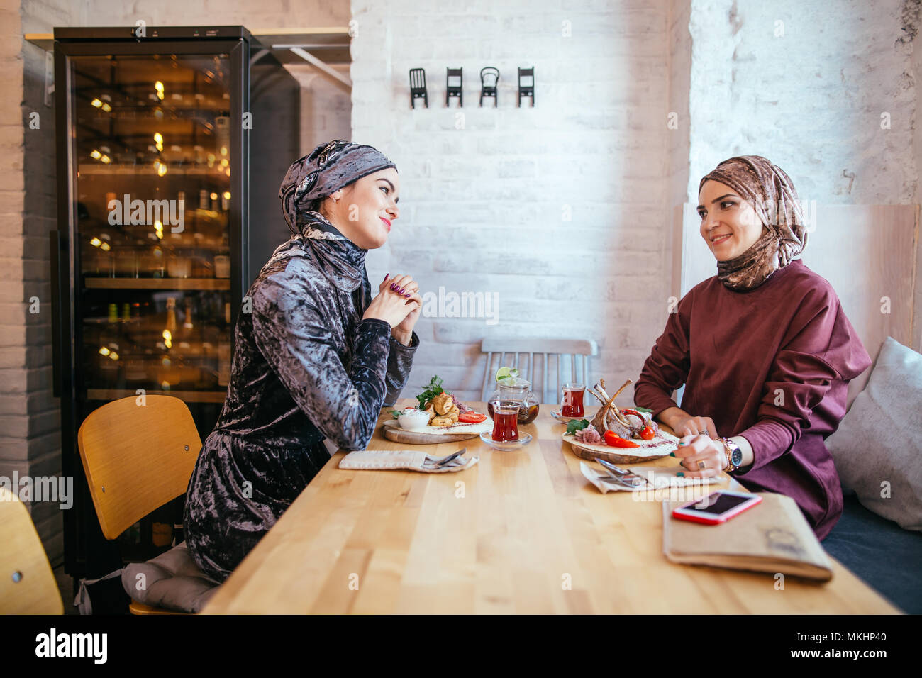 Two Muslim Friends Enjoying food while sitting in cafe Stock Photo - Alamy