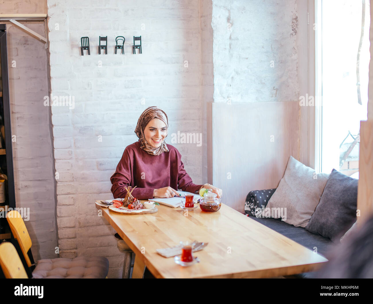 beautiful muslim woman writing on paper at cafe Stock Photo - Alamy