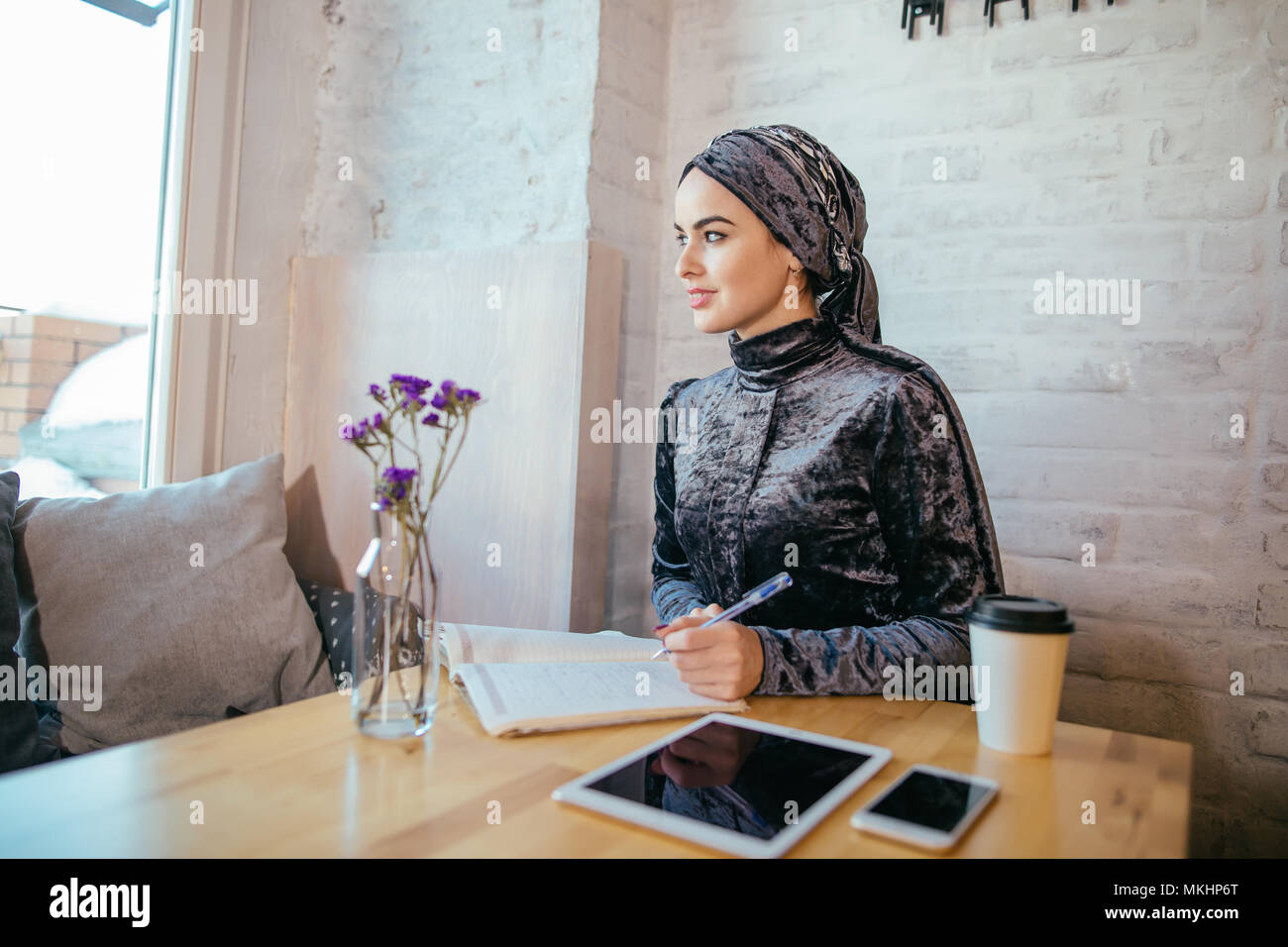 beautiful muslim woman writing on paper at cafe Stock Photo - Alamy