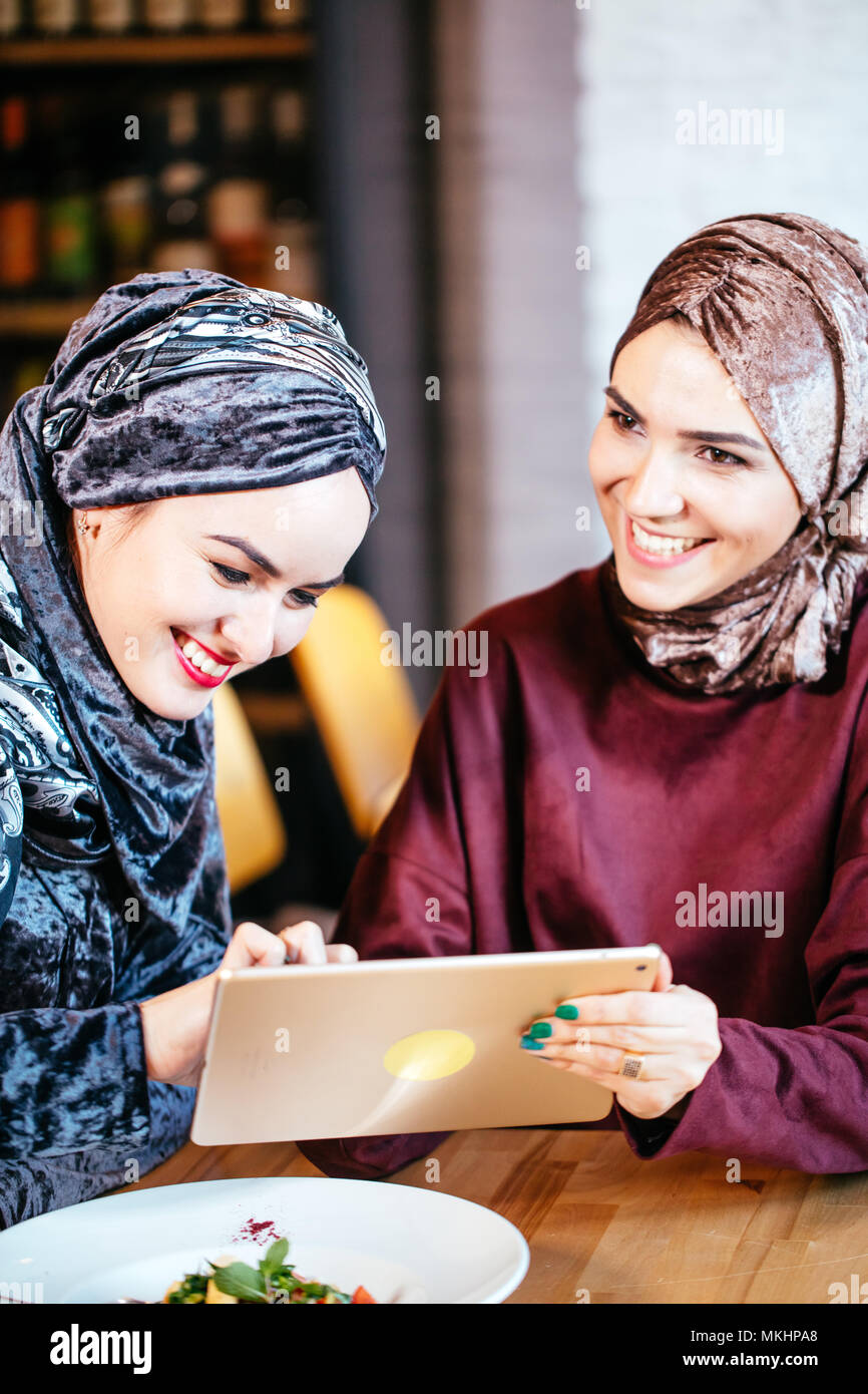 Two Muslim women with beauty smile using digital tablet Stock Photo - Alamy