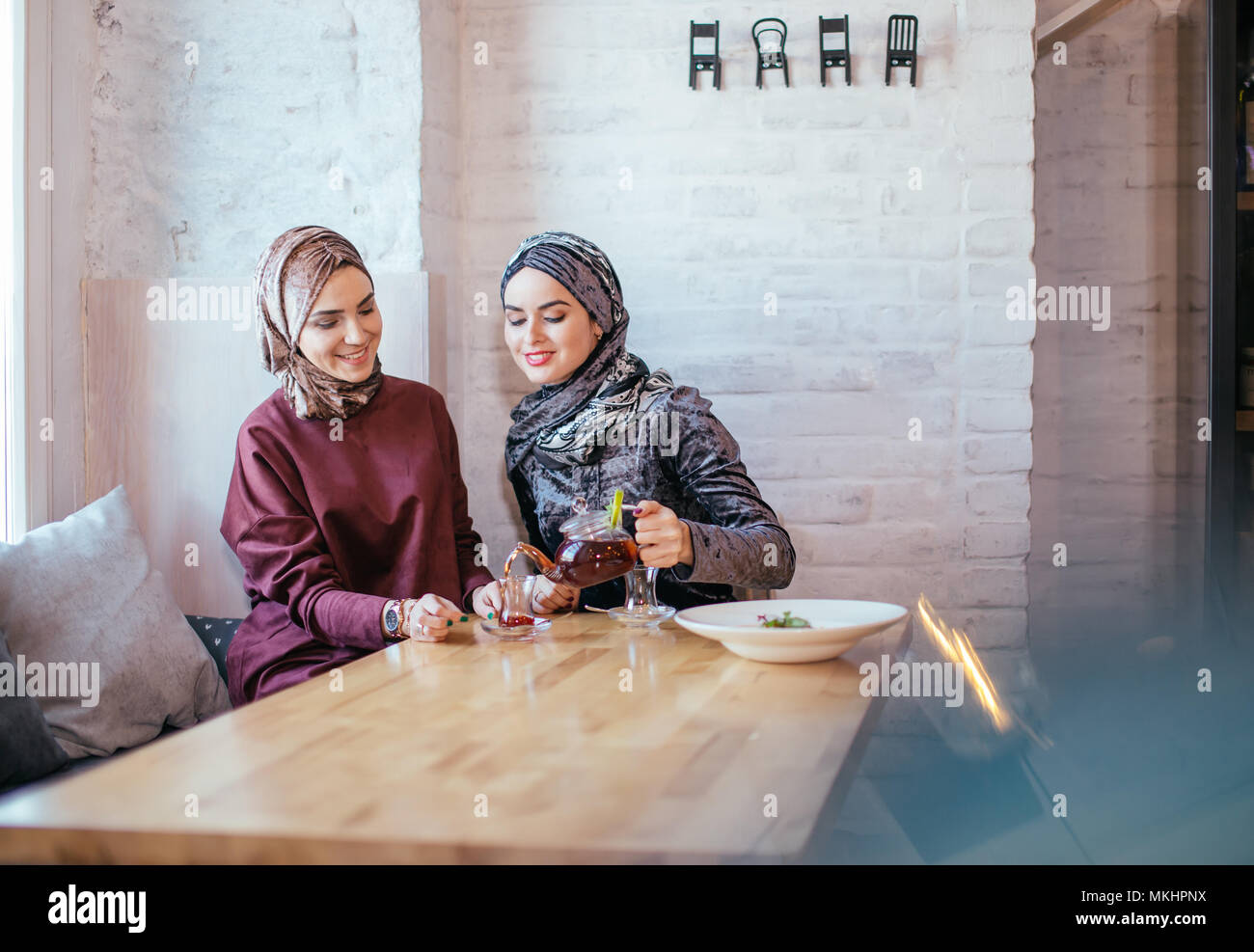 two Pretty caucasian muslim woman drinking tea in cafe Stock Photo - Alamy
