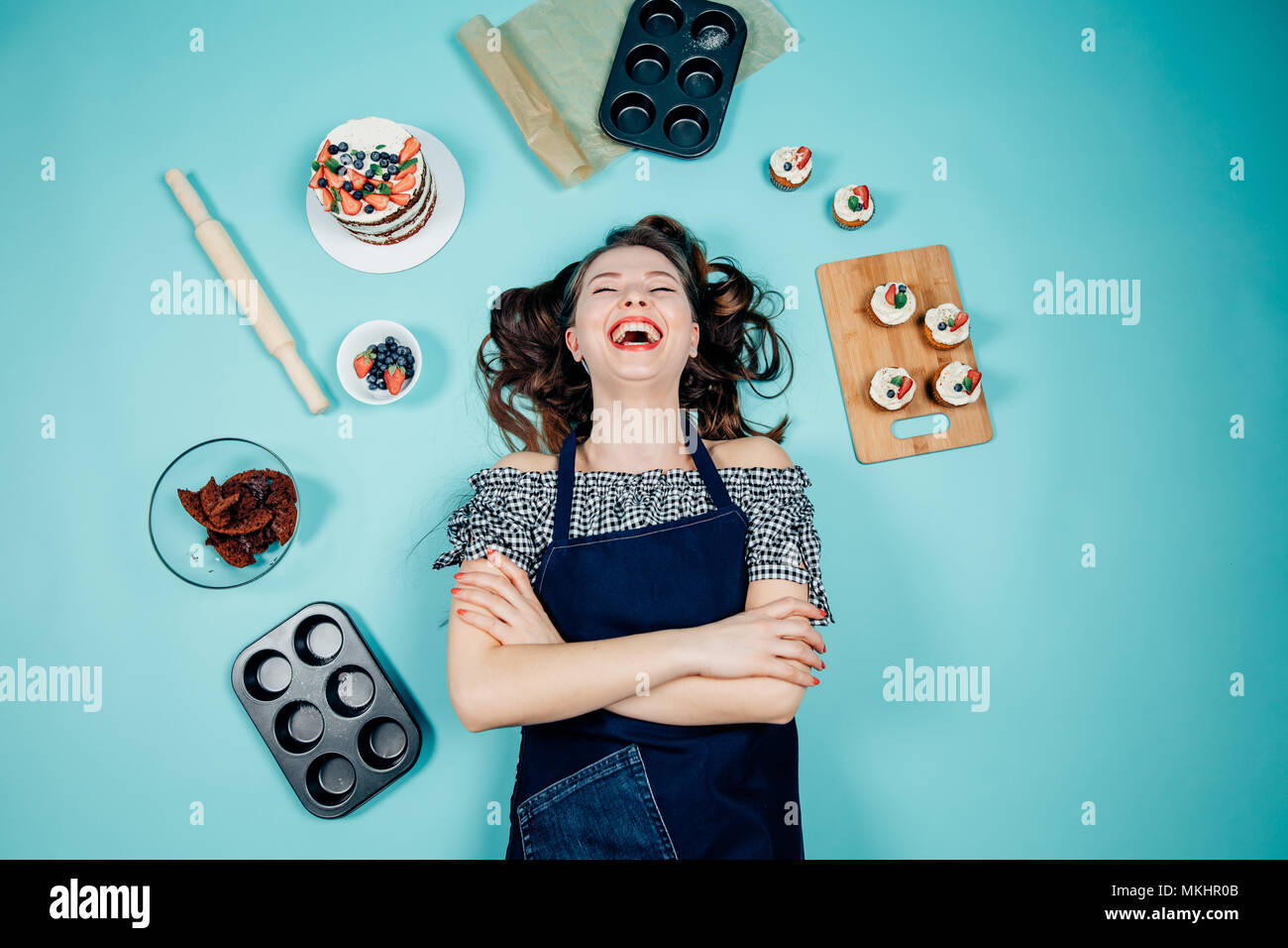 Young female dressed laughing and having fun at cooking masterclass ...