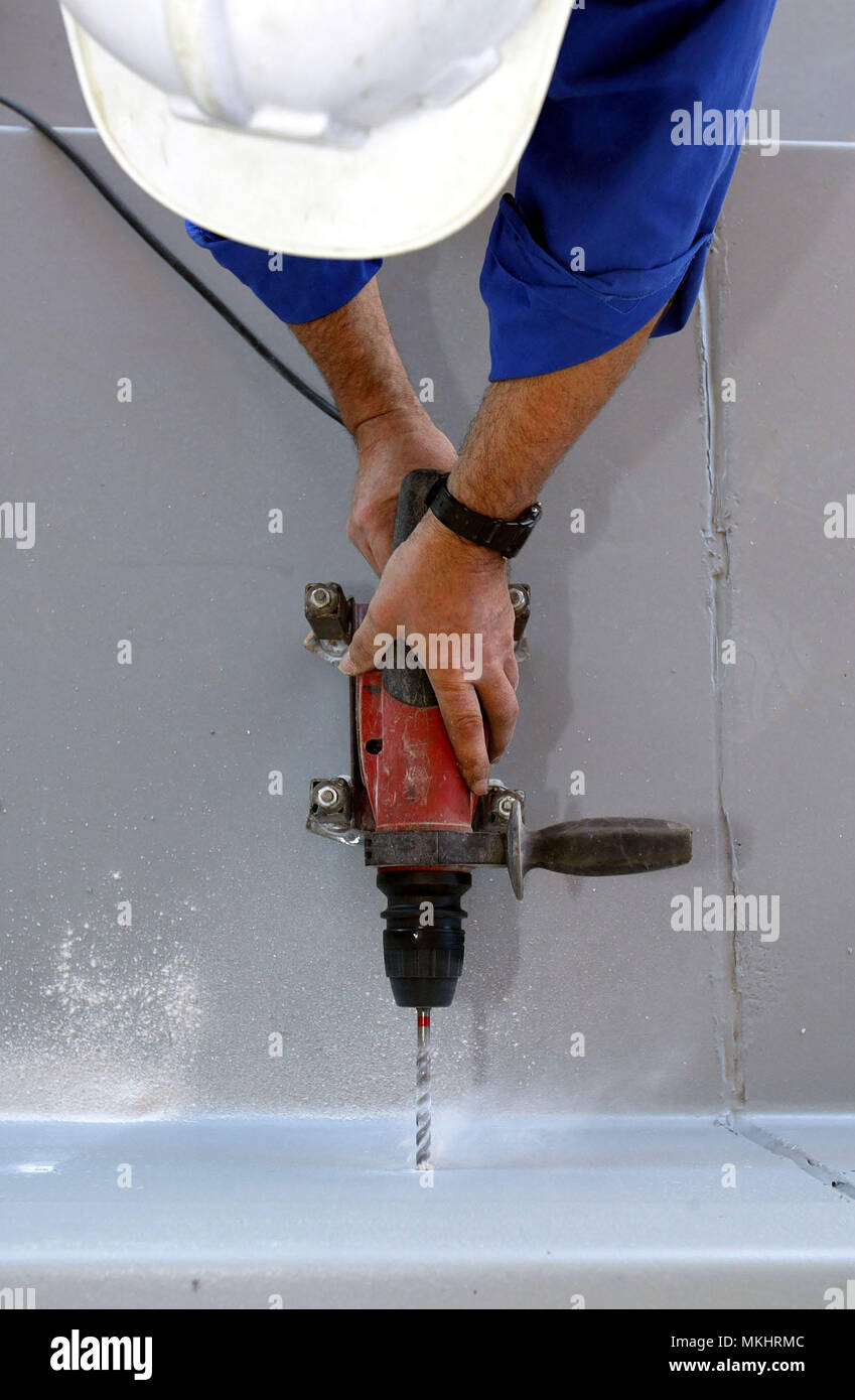 Overhead view of a man drilling a cement wall with a power drill Stock ...