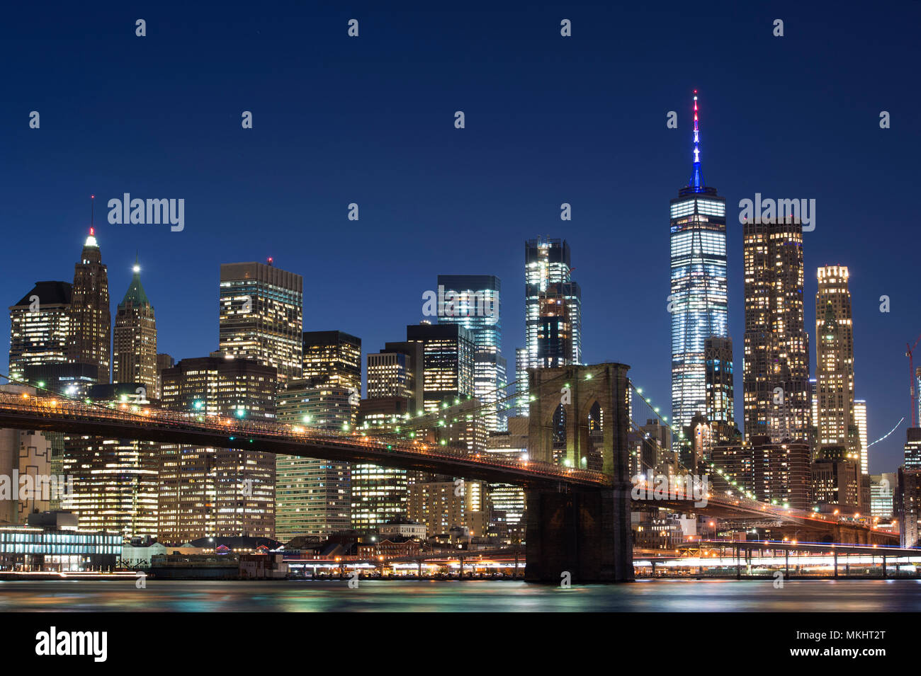 Brooklyn Bridge and the illuminated Skyline of Manhattan in the evening ...
