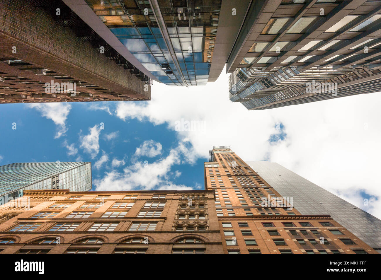 View from the bottom to top of some skyscrapers in Manhattan, blue sky ...