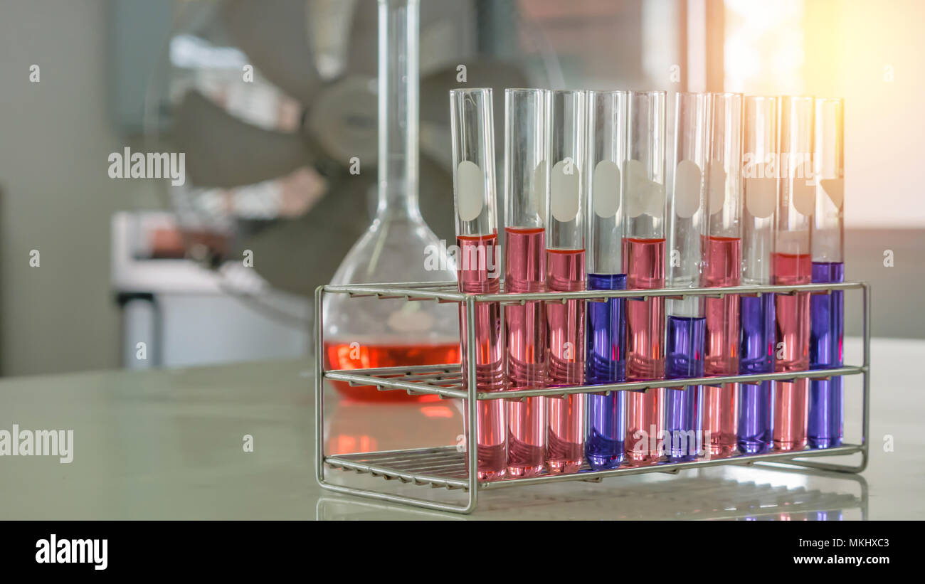 Different laboratory test tubes with colored liquid and with reflection ...
