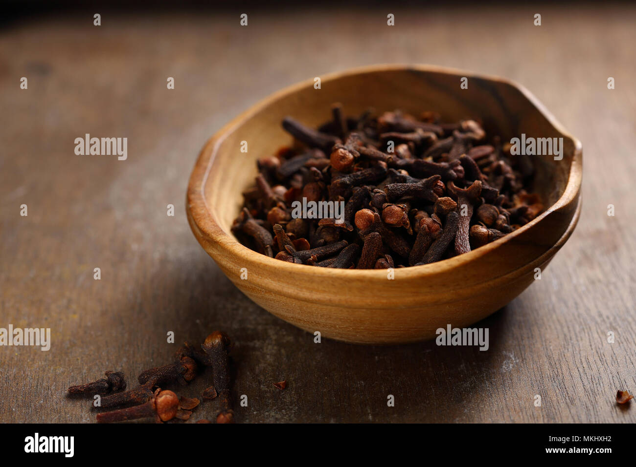 Scented cloves in bowl, spice closeup Stock Photo - Alamy