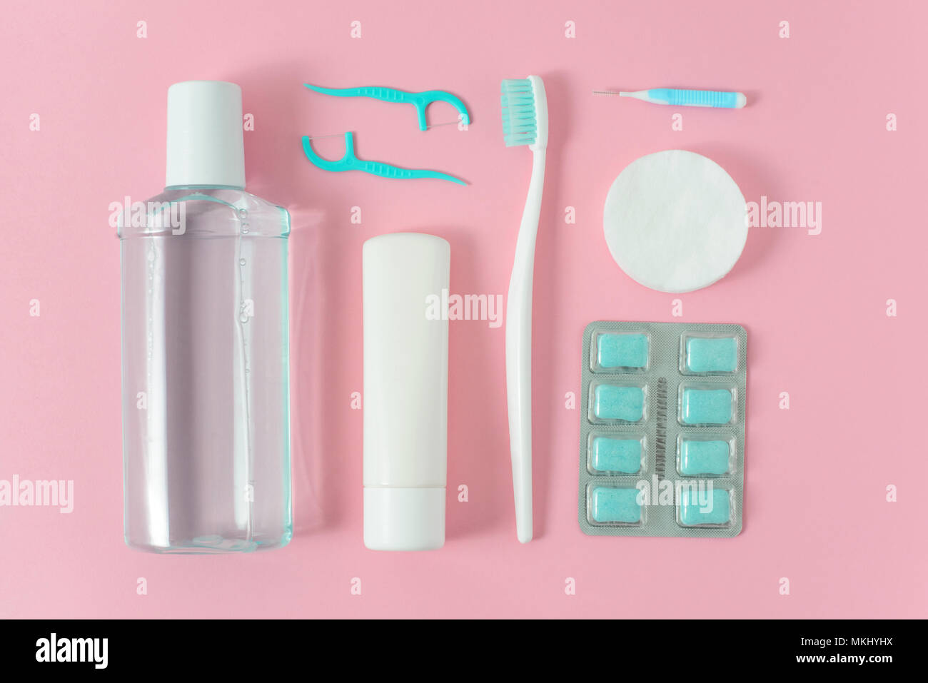 Toothbrushes, toothpaste, rinse and chewing gum set on pink background ...