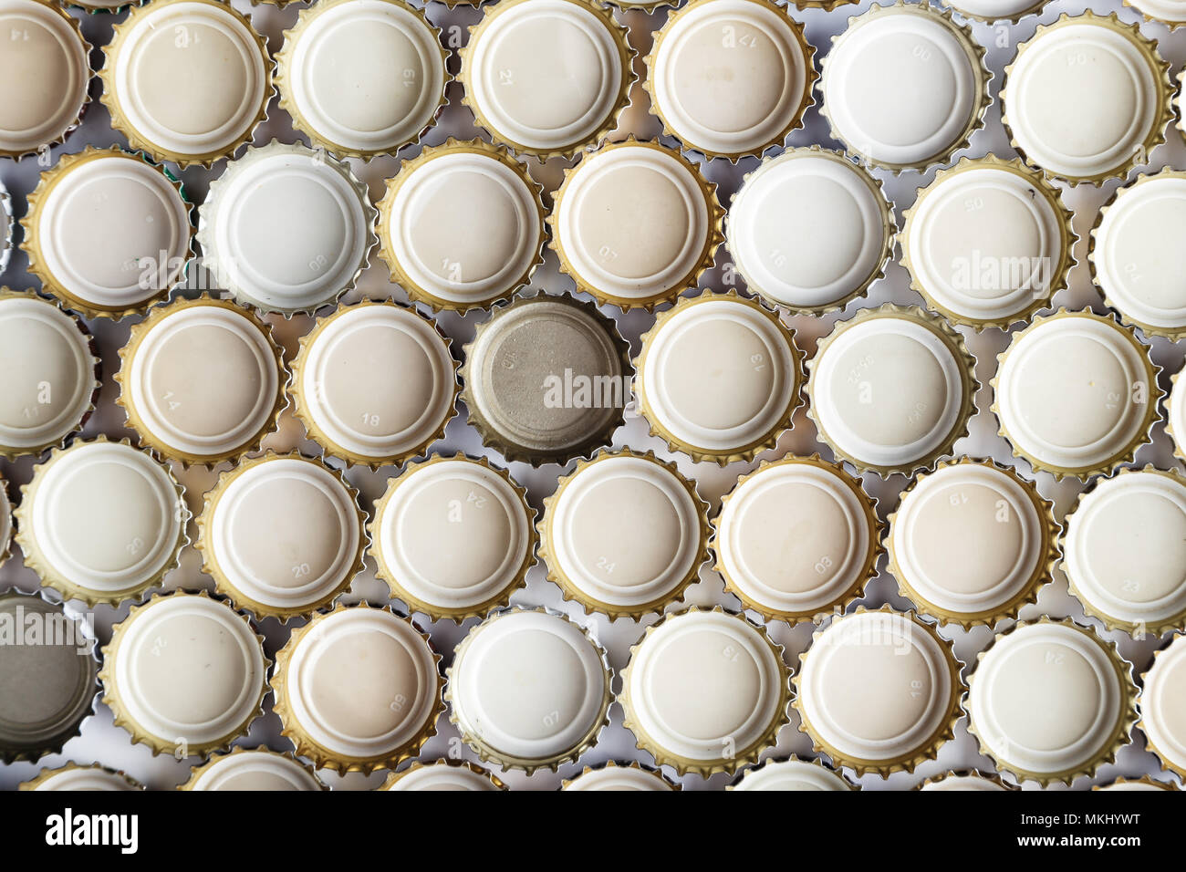 many inverted covers of beer are laid out in rows, the background. top ...