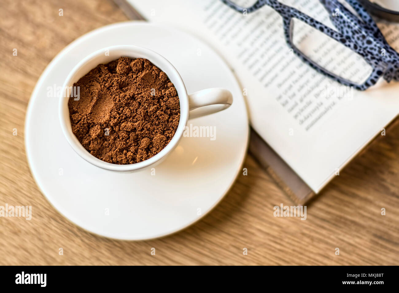 Ground turkish coffee in white coffee cup with open book and reading ...