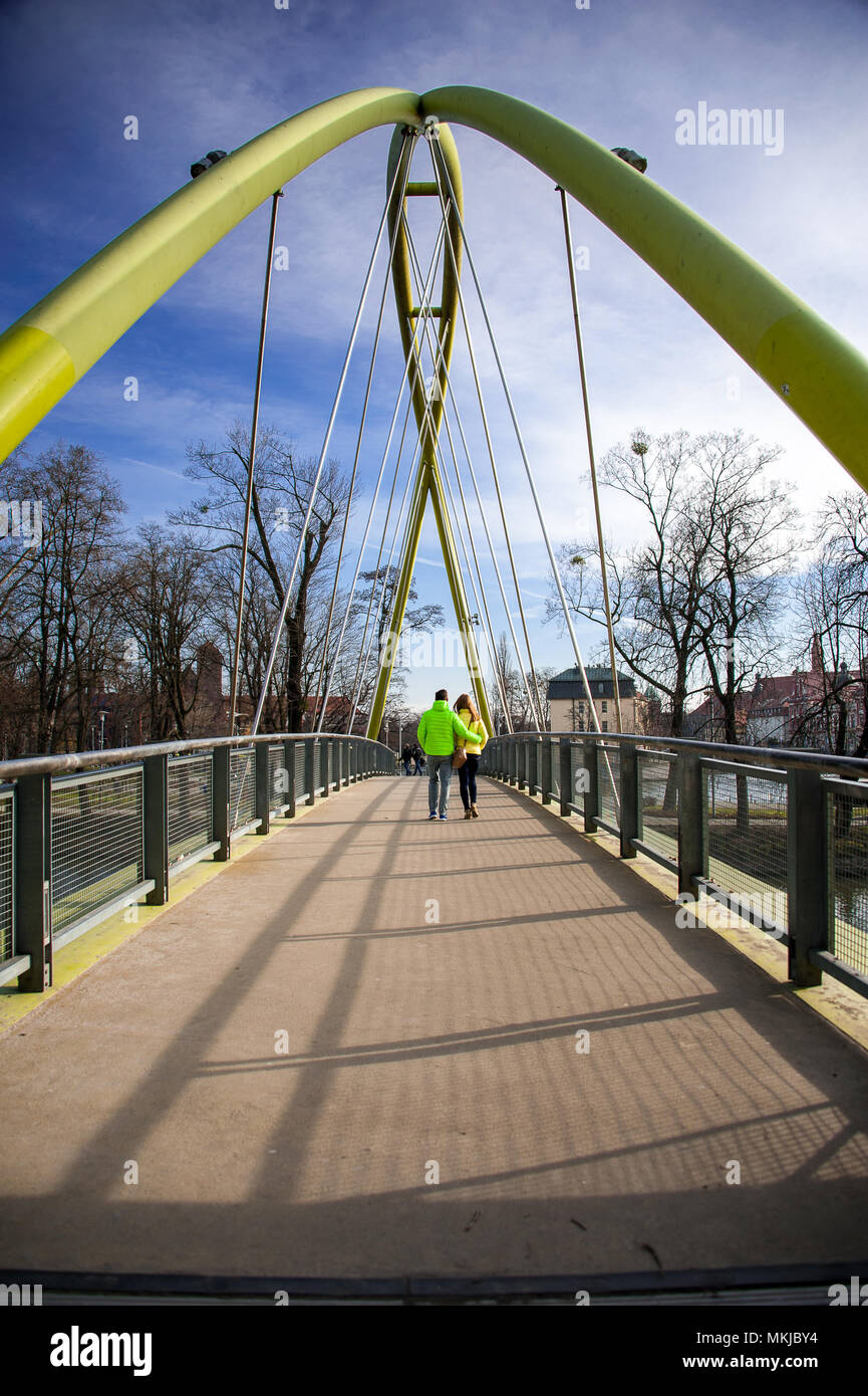 A young couple walk arm in arm across the Malt footbridge (Kladka ...
