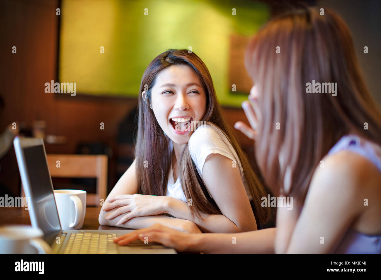 two girls having fun in coffee shop Stock Photo - Alamy
