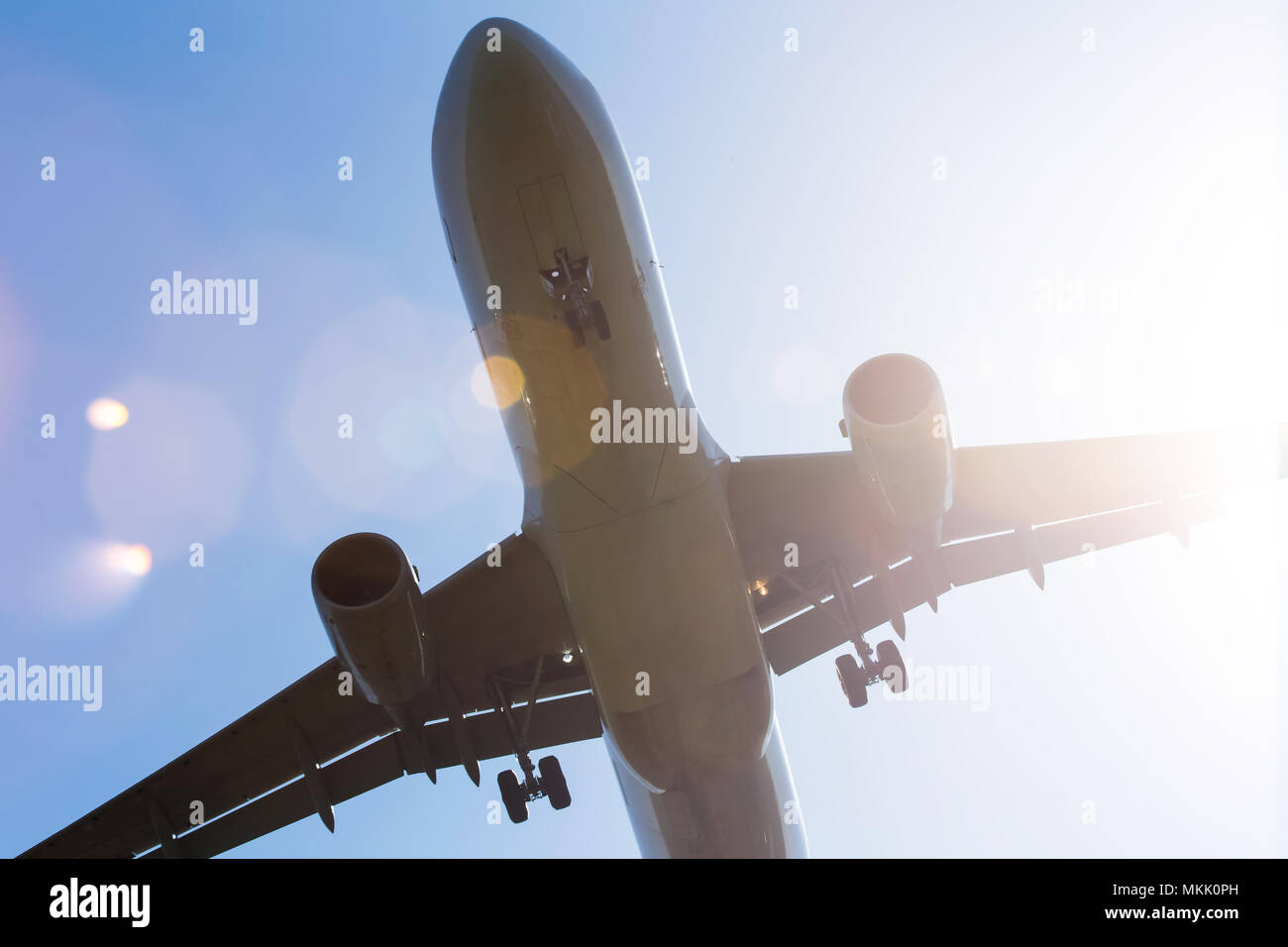 airplane in the sky from underneath with sun rays Stock Photo - Alamy