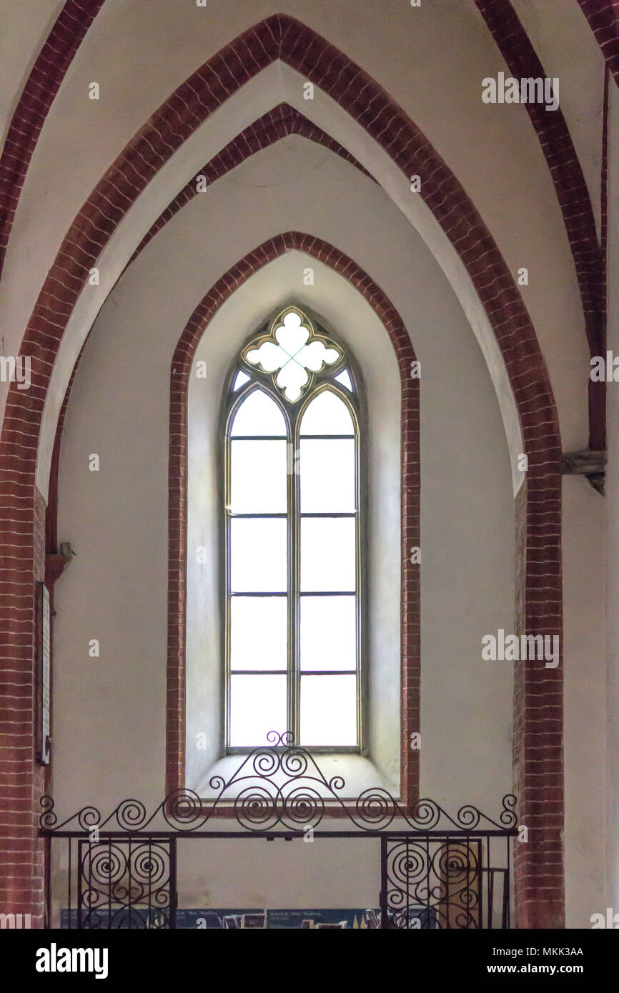 Interior of a brick cathedral in the Gothic style.A narrow high Lancet ...