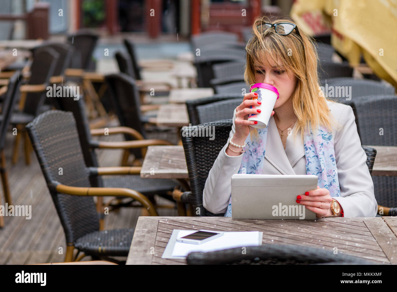 A young business woman drinking tea in a cafe and working with a ...