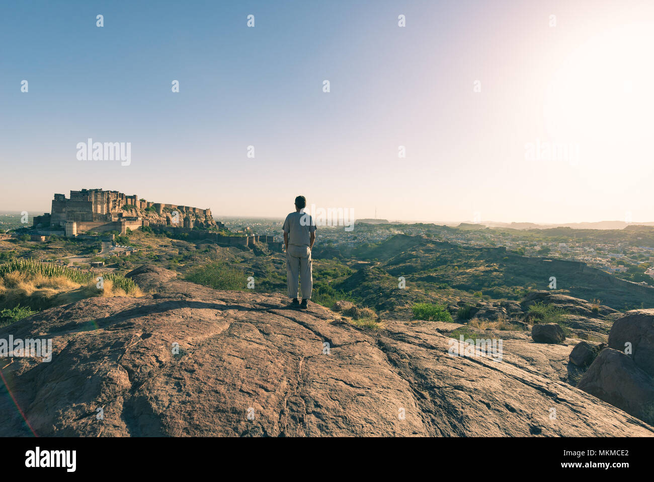Tourist standing on rock and looking at expansive view of Jodhpur fort ...