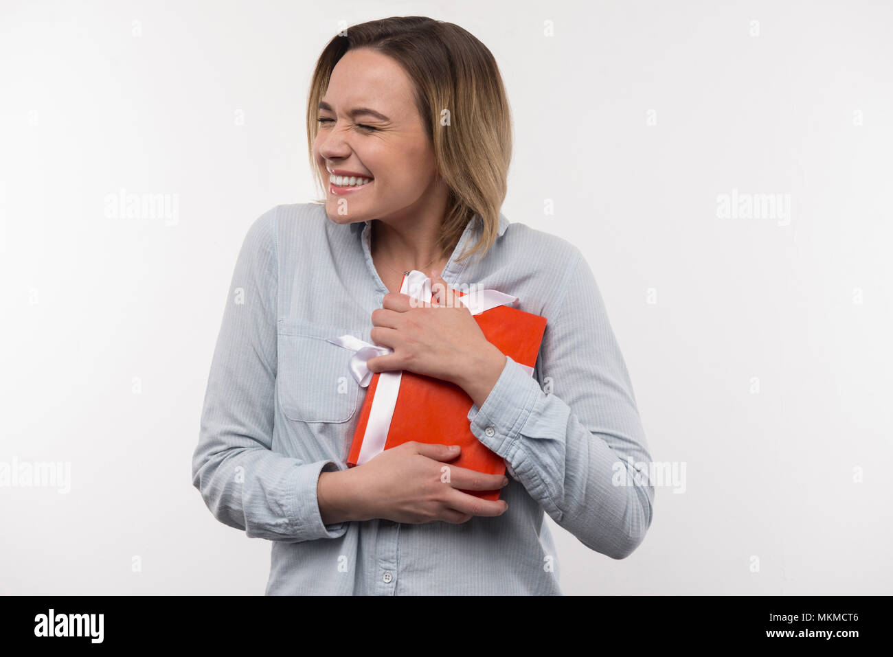 Delighted nice woman holding the present Stock Photo - Alamy