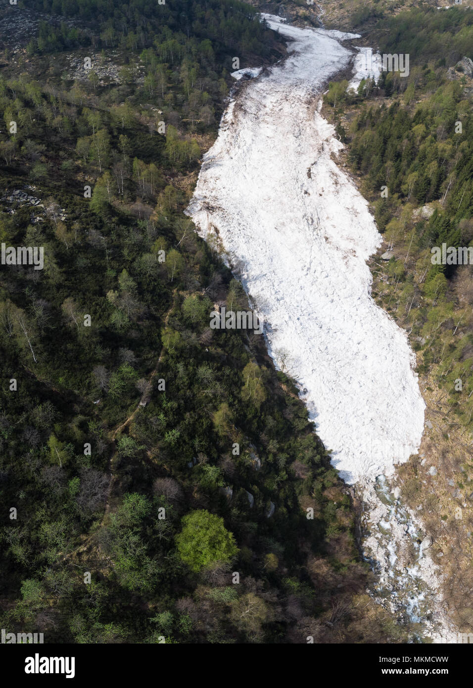 Aerial: huge snow avalanche fallen in springtime in alpine valley ...