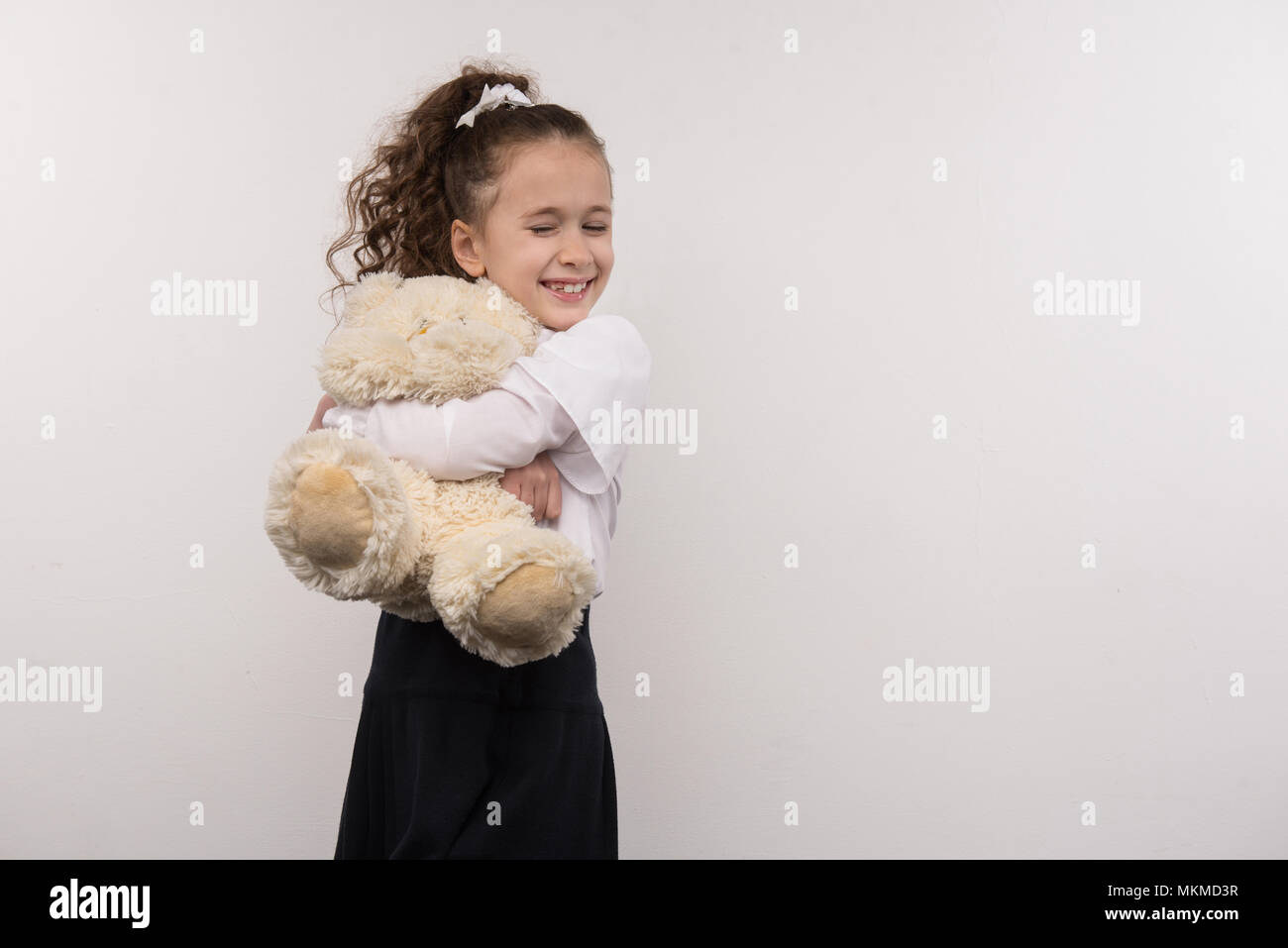 Happy young girl hugging her toy Stock Photo - Alamy